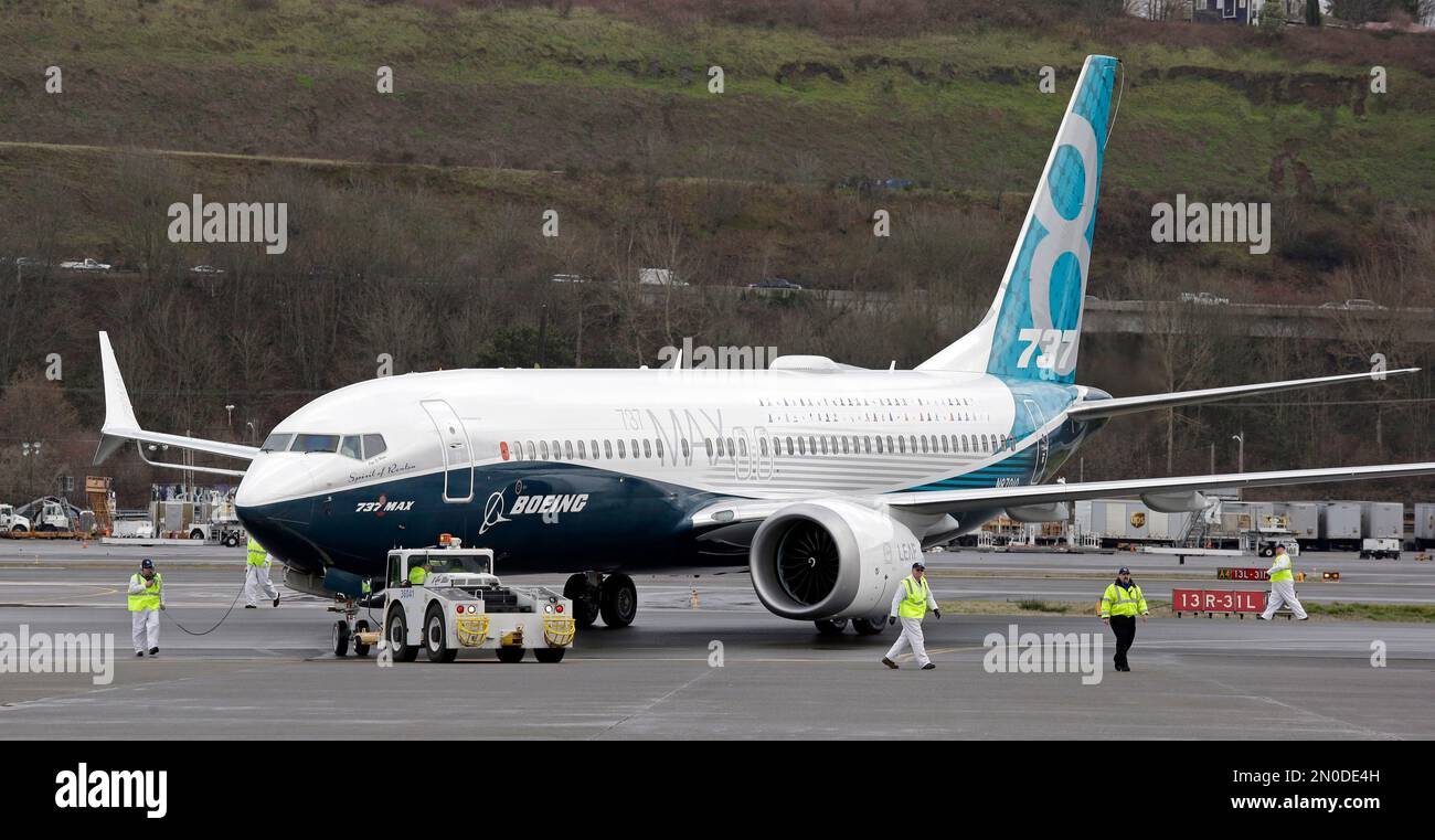 Workers escort a Boeing 737 MAX jetliner after its landing Friday, Jan ...