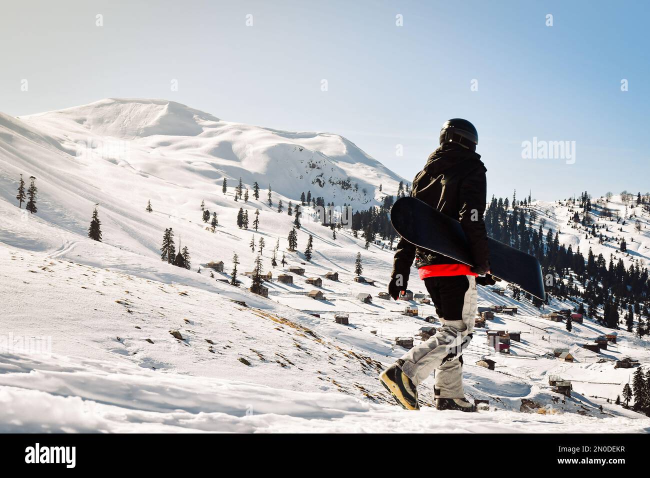 Male snowboarder dressed in dark black sportswear walk enjoy views ...