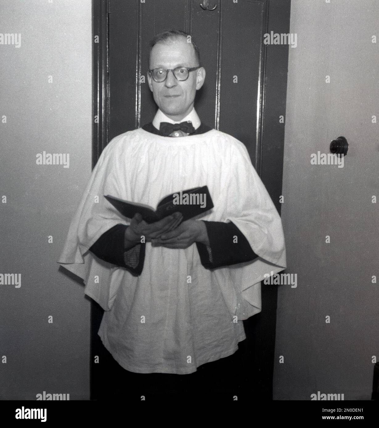 1950s, historical, a choir man standing in his outfot and holding his ...