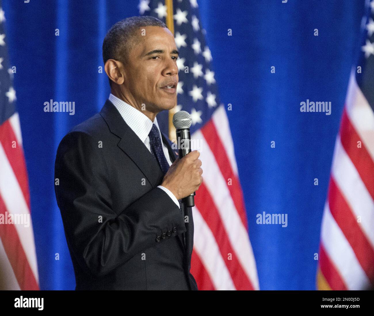 President Barack Obama picks up a microphone to take questions from ...