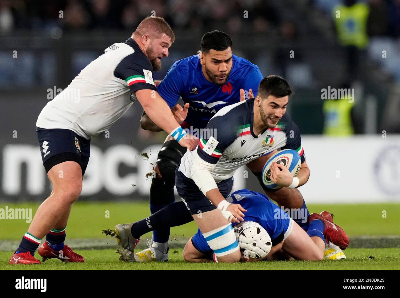 Italy's Edoardo Iachizzi, front, holds the ball as he is tackled by ...