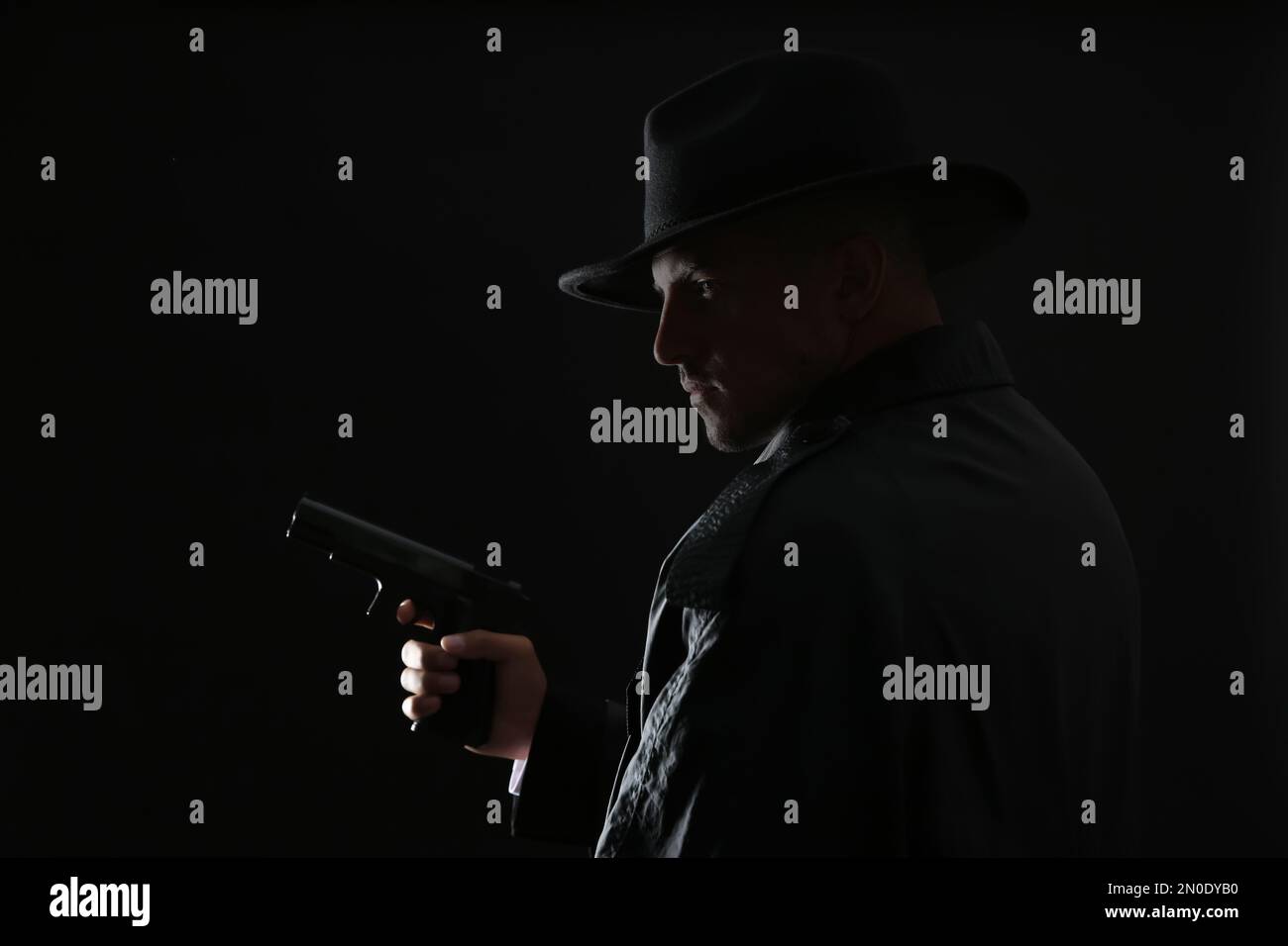 Old fashioned detective with gun on dark background Stock Photo - Alamy