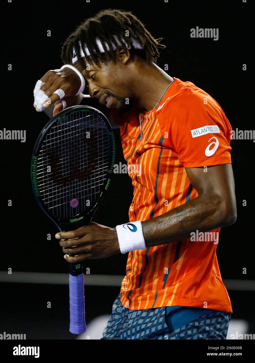 Gael Monfils of France wipes the sweat from his face during his ...