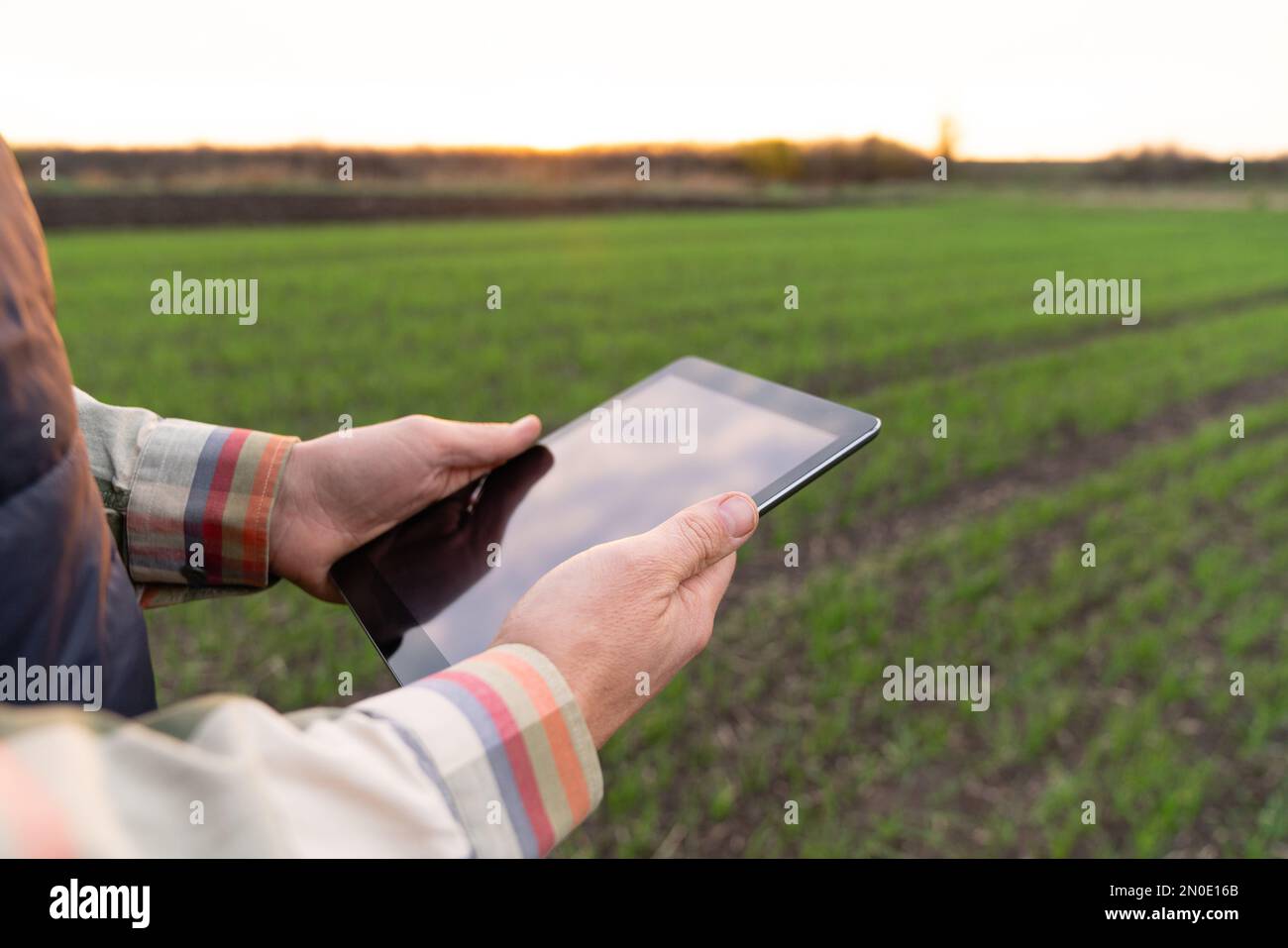 Farmer with digital tablet on an agricultural field. Close up. Smart ...