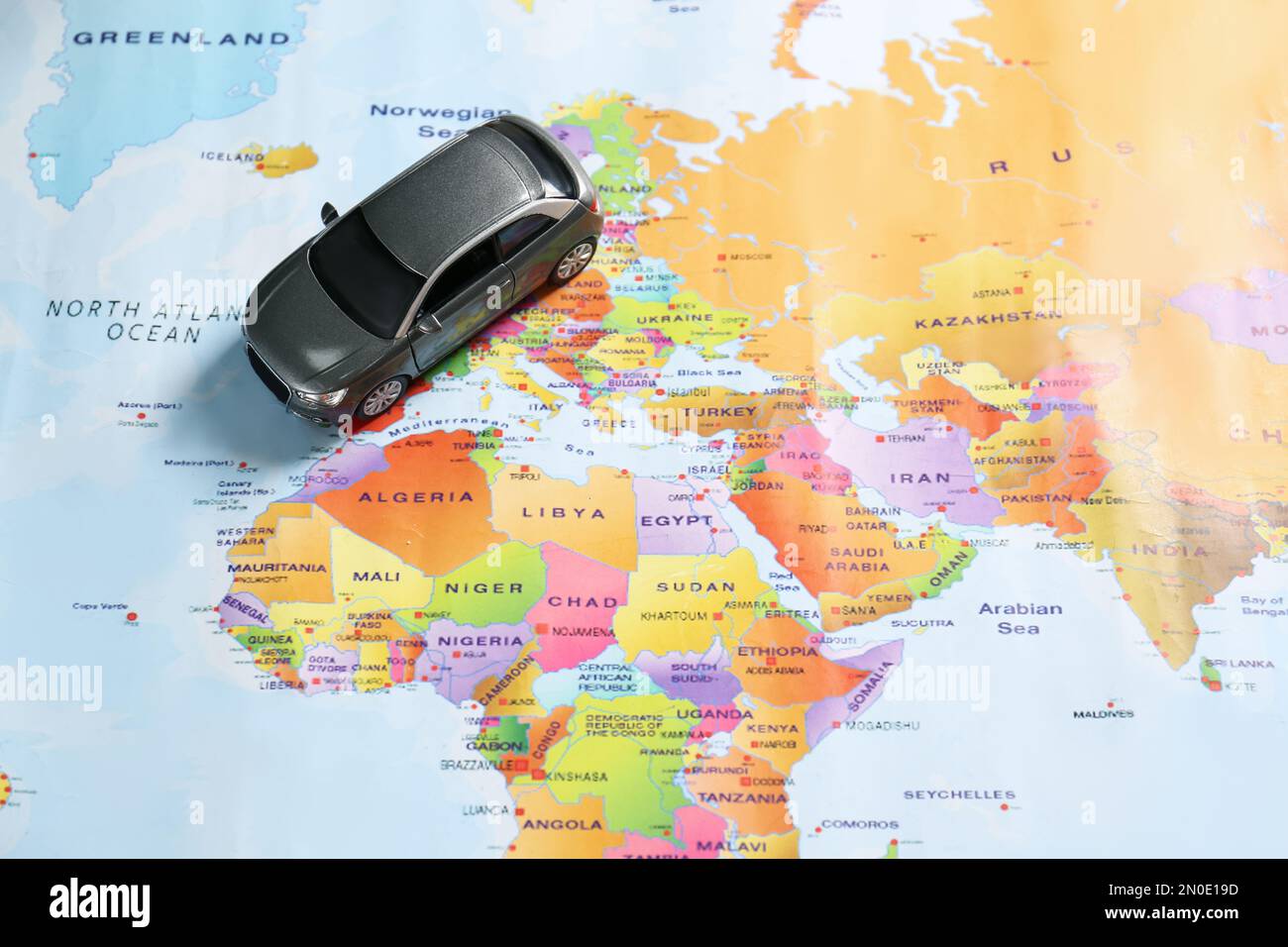 Grey toy car on world map. Trip planning Stock Photo - Alamy