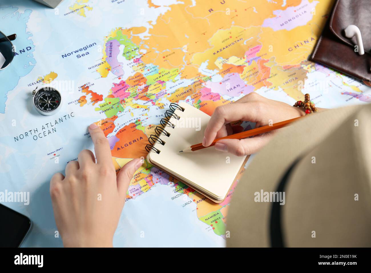 Woman using world map to plan trip at wooden table, closeup Stock Photo ...
