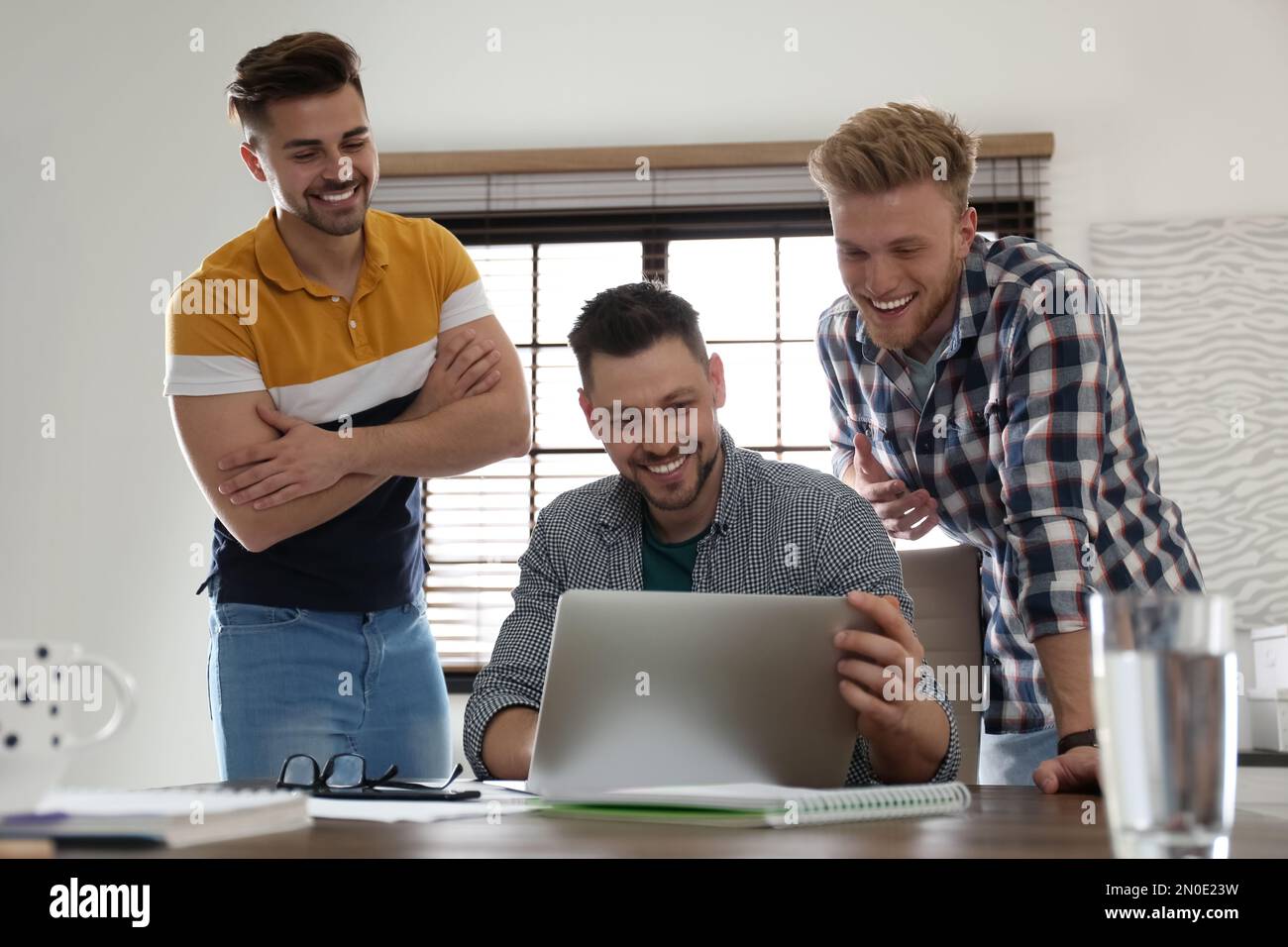 Happy friends working together in modern office Stock Photo - Alamy