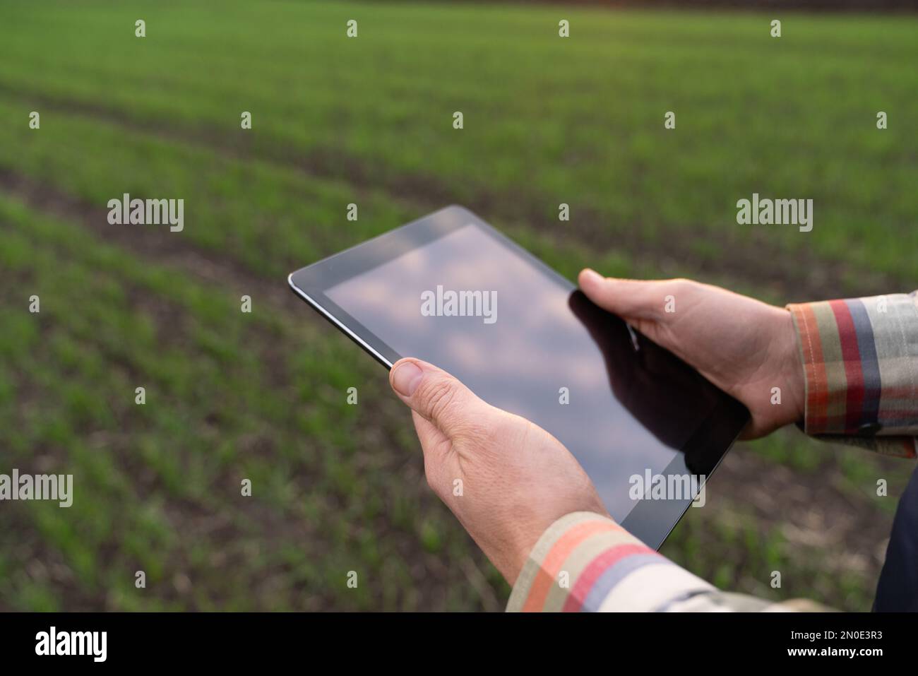 Farmer with digital tablet on an agricultural field. Close up. Smart ...