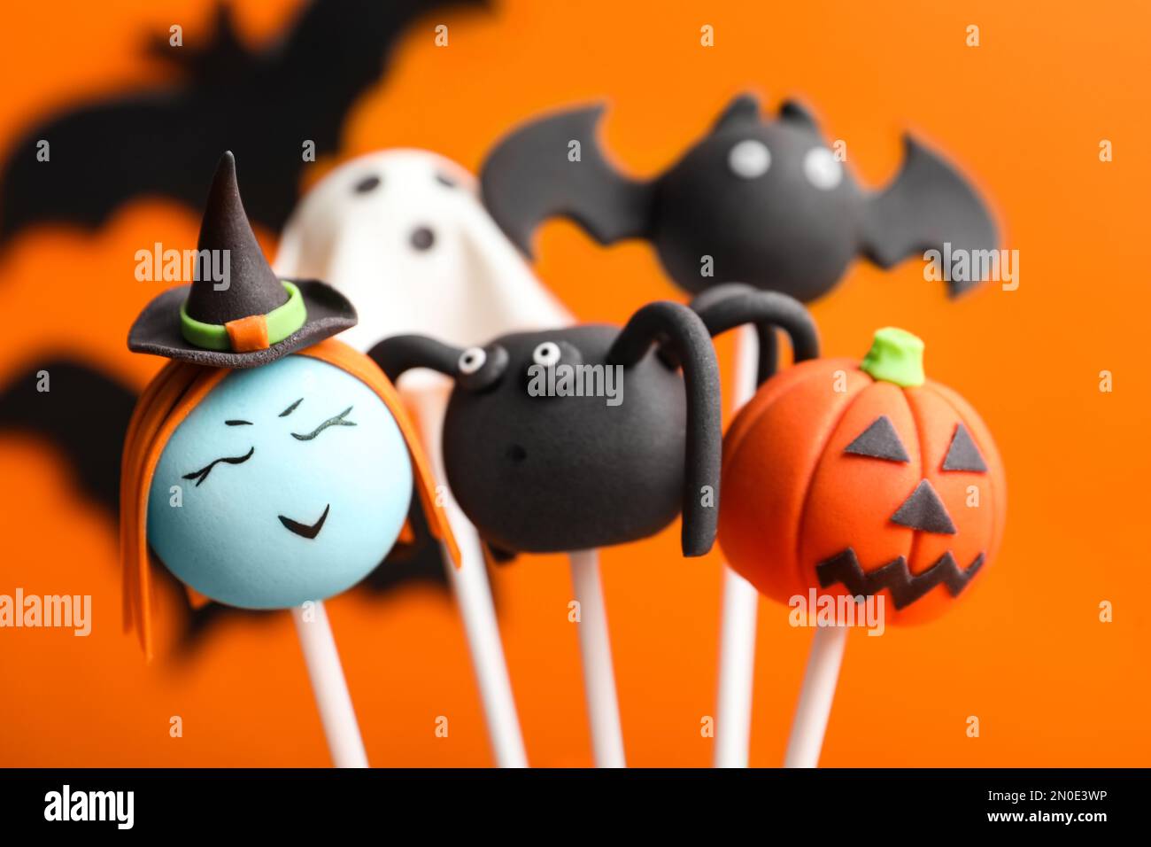 Delicious Halloween themed cake pops on orange background, closeup ...