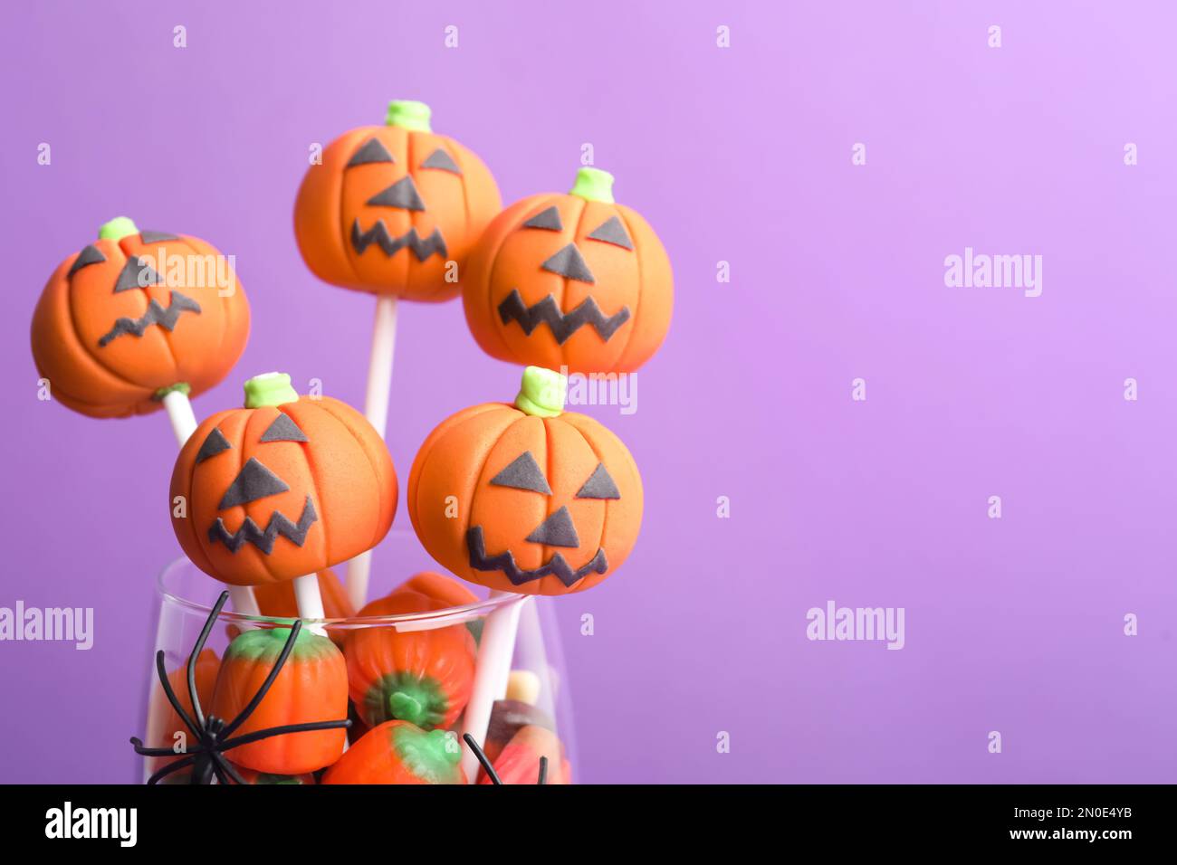 Delicious Halloween themed cake pops on violet background, closeup ...
