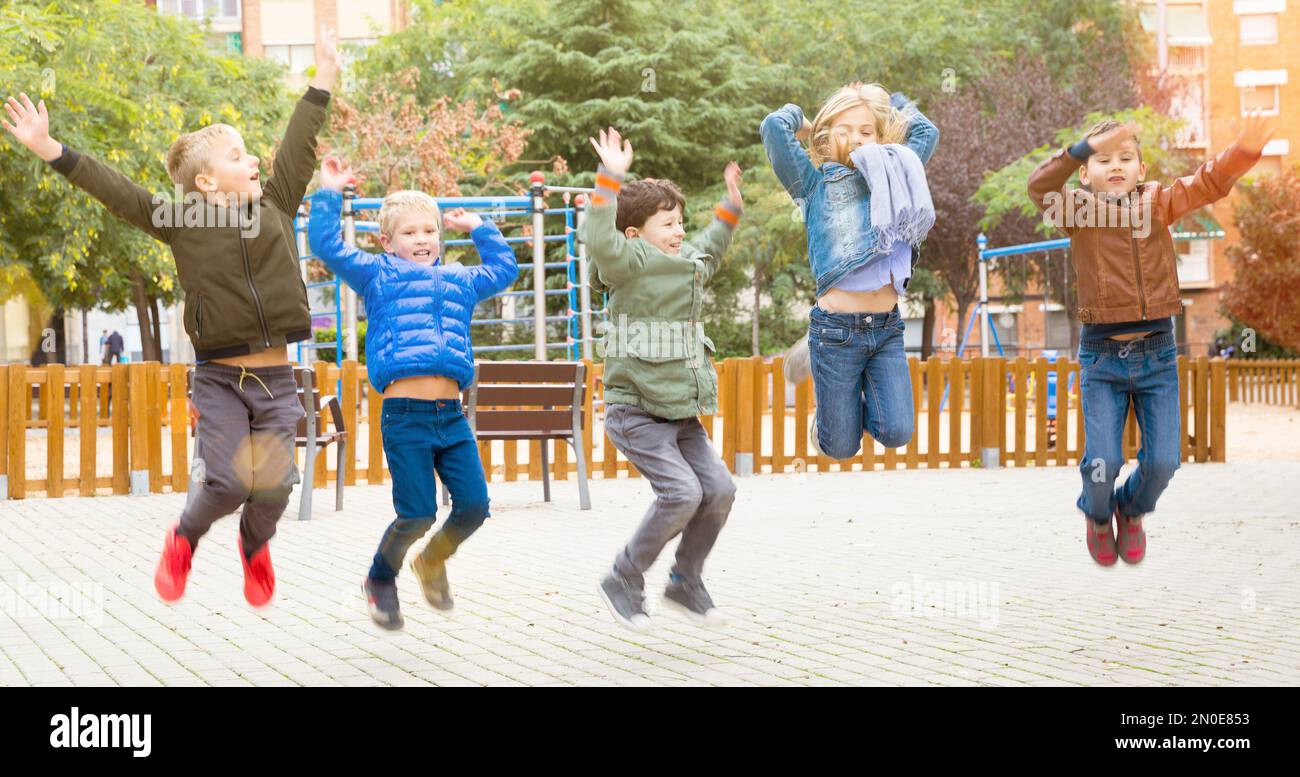 Happy children jumping together Stock Photo - Alamy