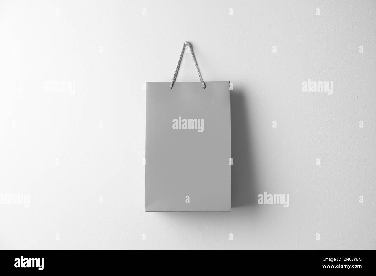 Paper shopping bag hanging on white wall Stock Photo - Alamy