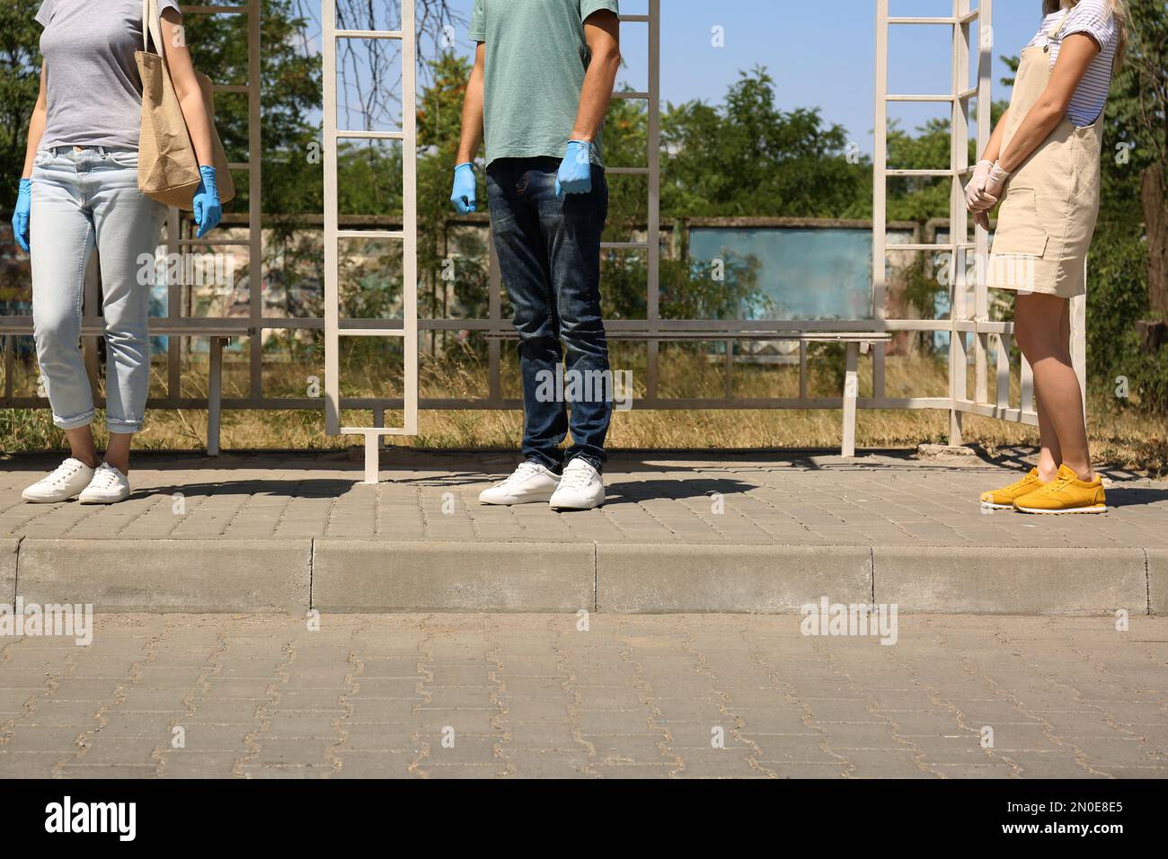 People keeping social distance in line at bus stop. Coronavirus ...