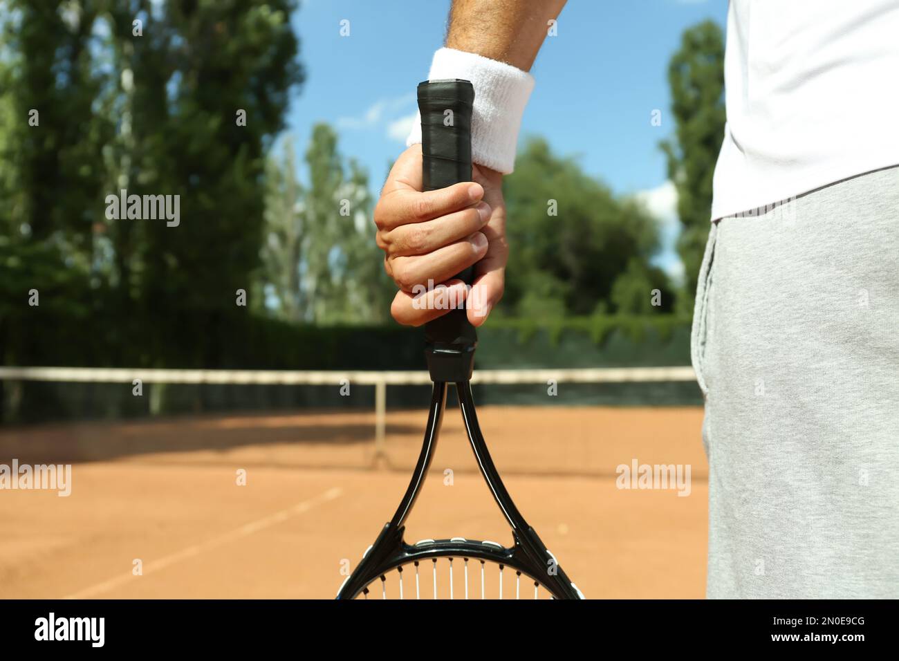 Sportsman with racket at tennis court, closeup Stock Photo - Alamy