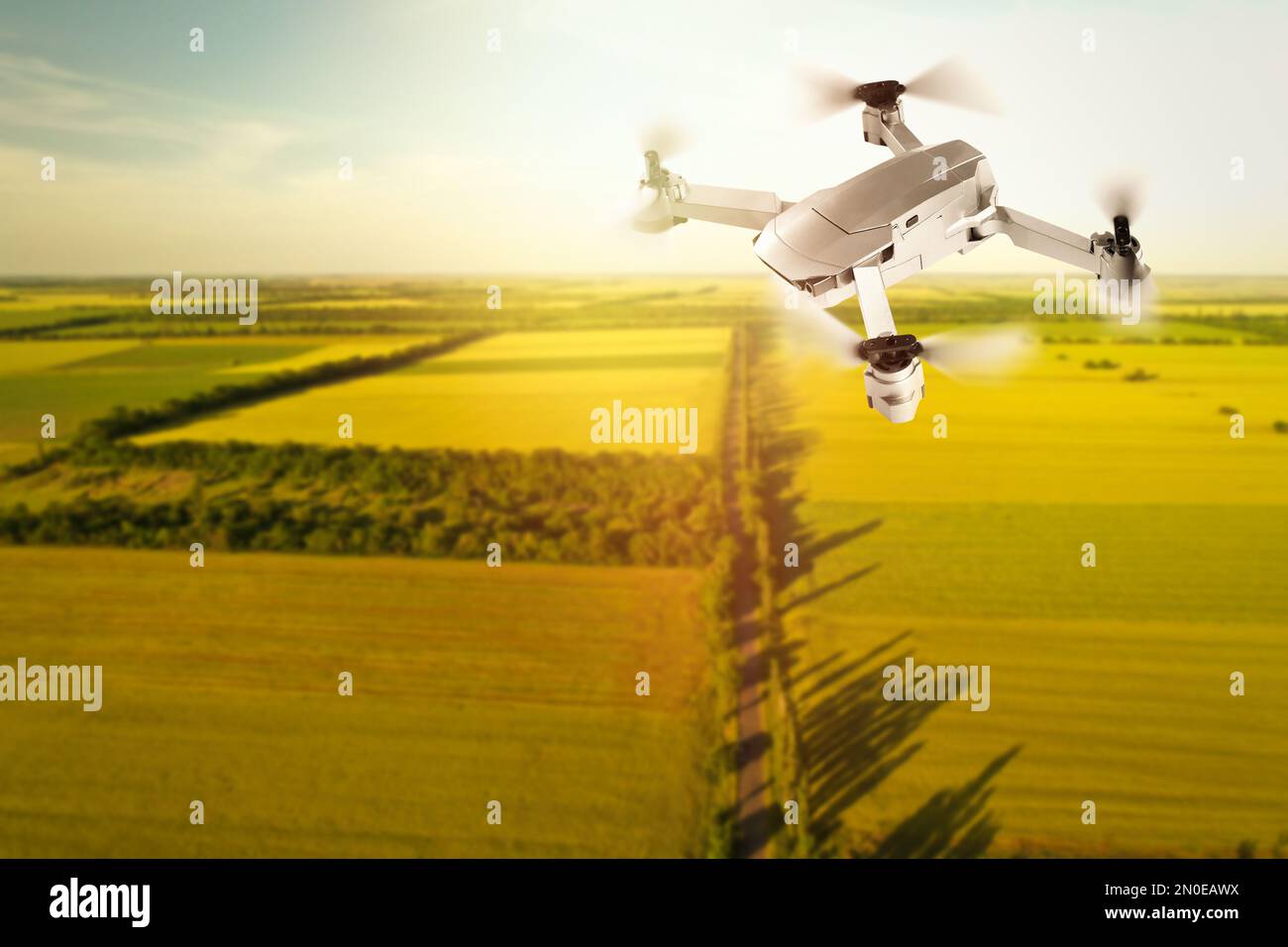 Modern drone flying over fields on sunny day. Aerial survey Stock Photo ...