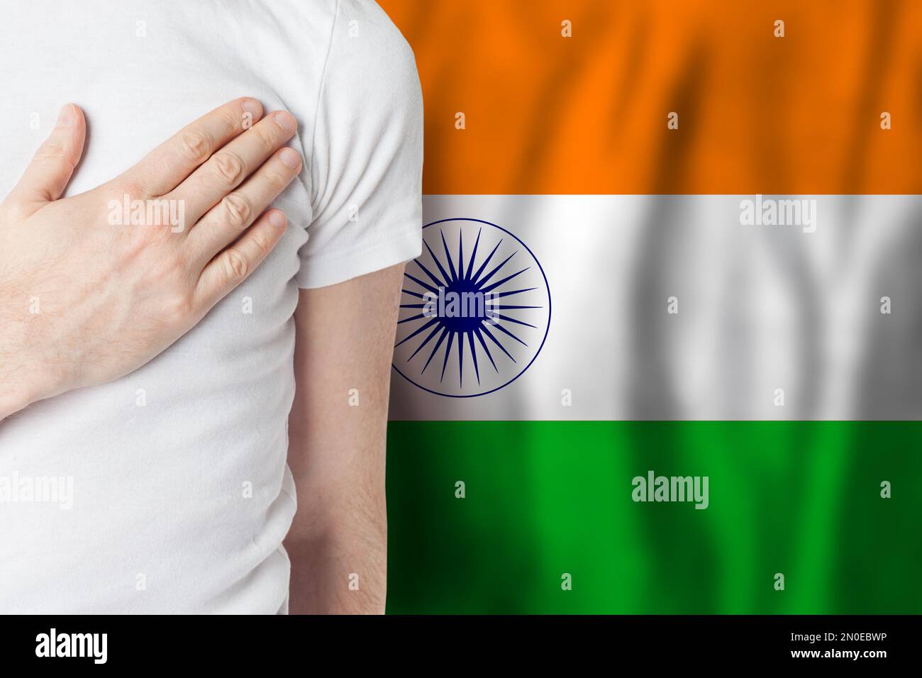 Indian person with hand on heart on the background of India flag ...