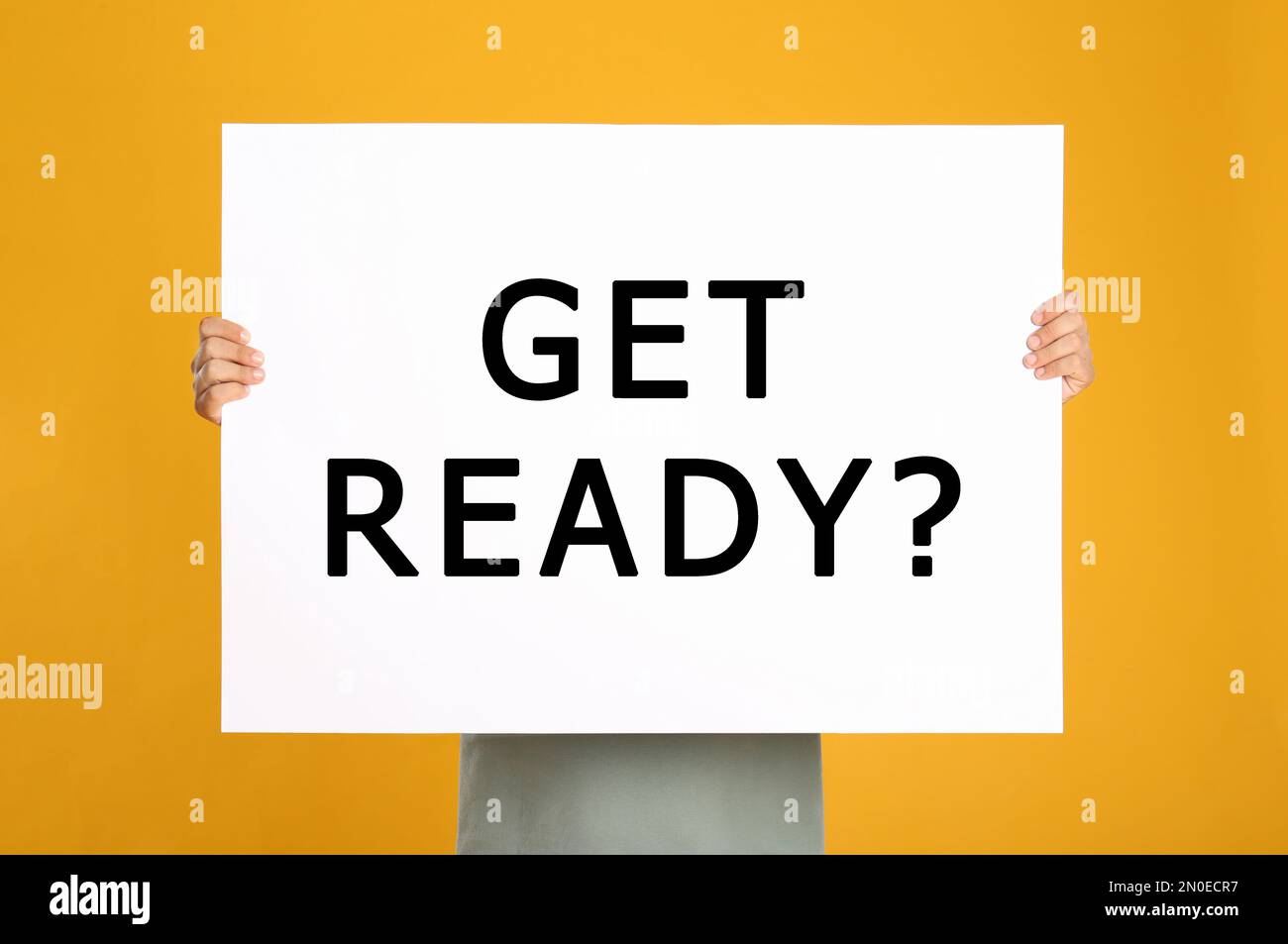 Man holding poster with text Get Ready? on yellow background Stock ...
