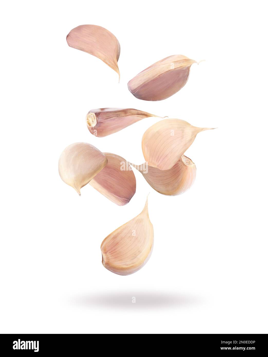 Many garlic cloves falling on white background Stock Photo - Alamy