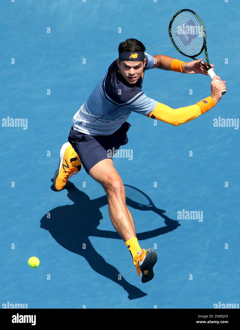 Milos Raonic of Canada makes a backhand return to Stan Wawrinka of ...