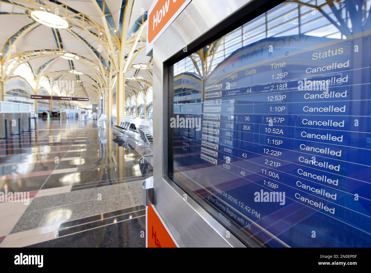 The sign shows a list of cancelled flights at Ronald Reagan National ...