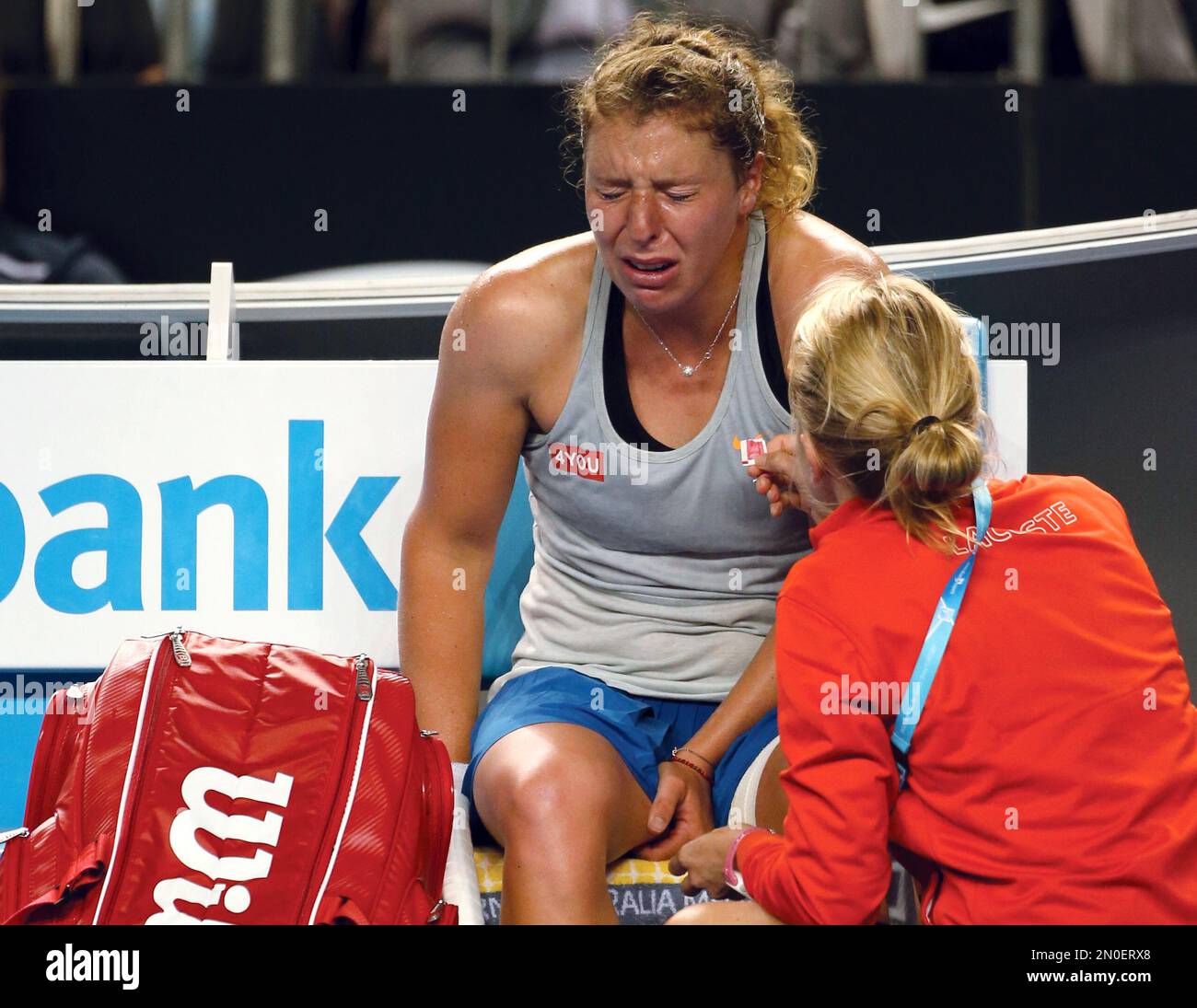 Anna-Lena Friedsam of Germany cries as a trainer assists her during her ...