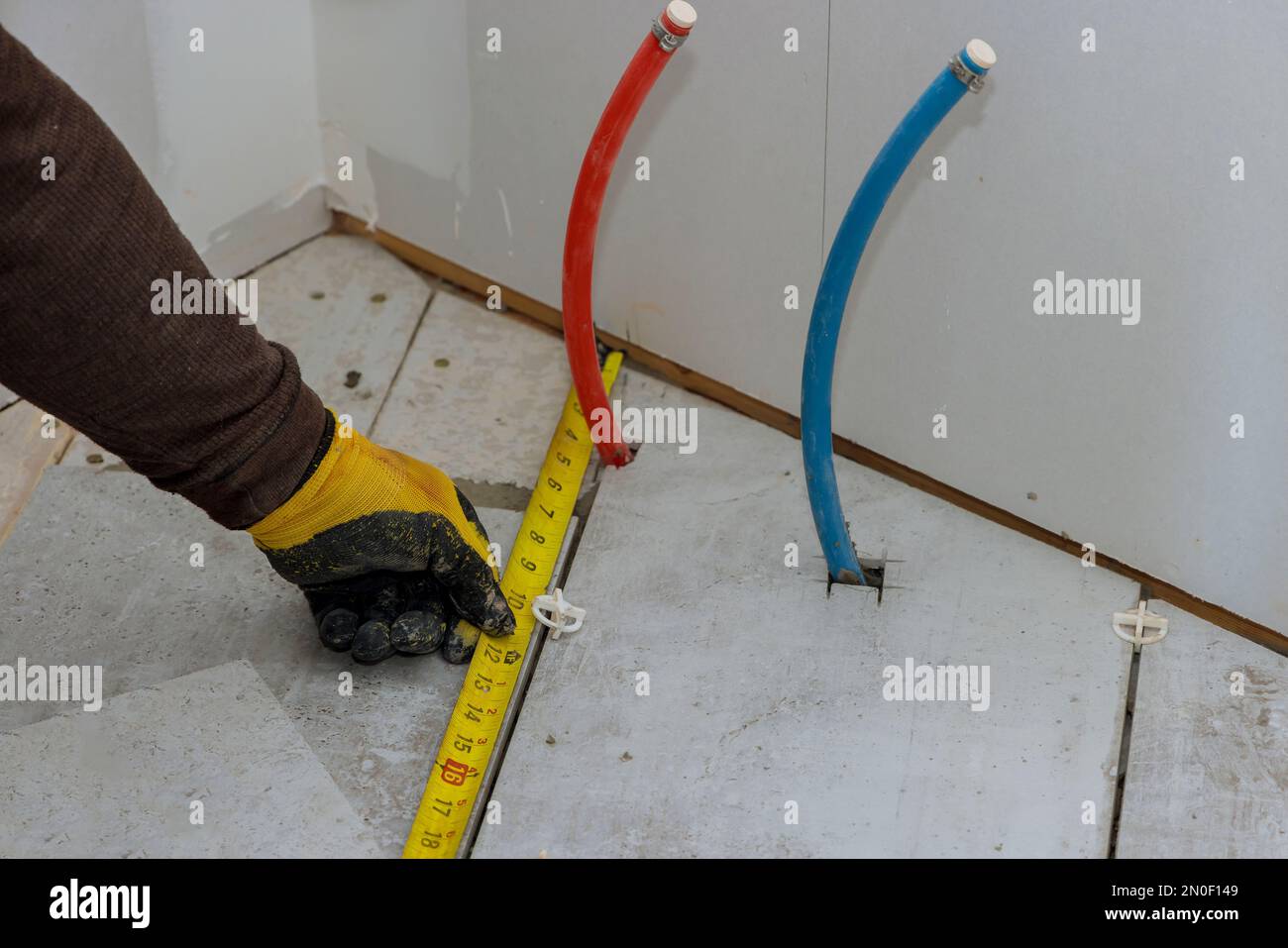 Preparing laying floor tiles an contractor measuring ceramic tile ...