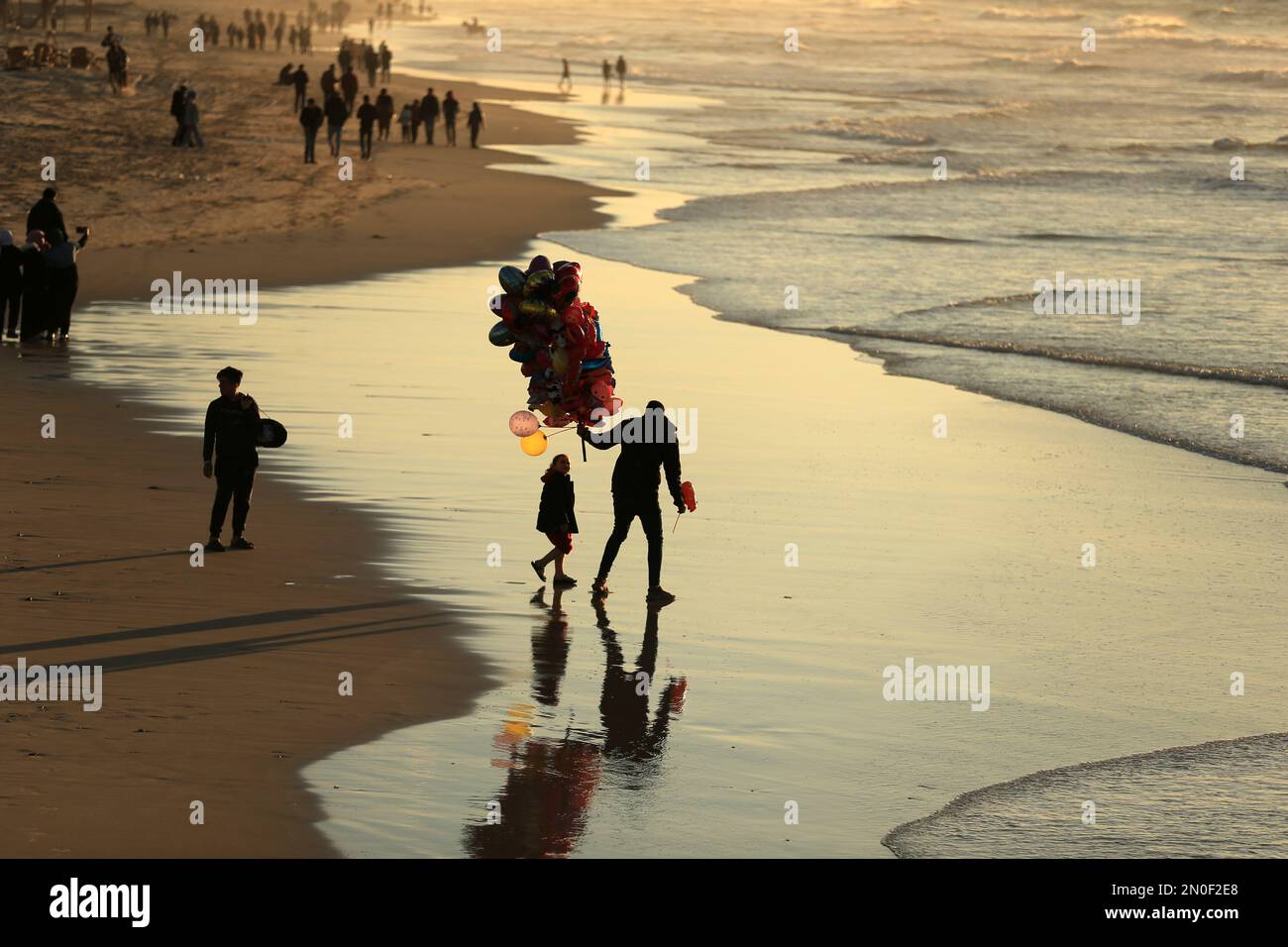 A Palestinian man sells balloons to children on the Gaza City beach ...