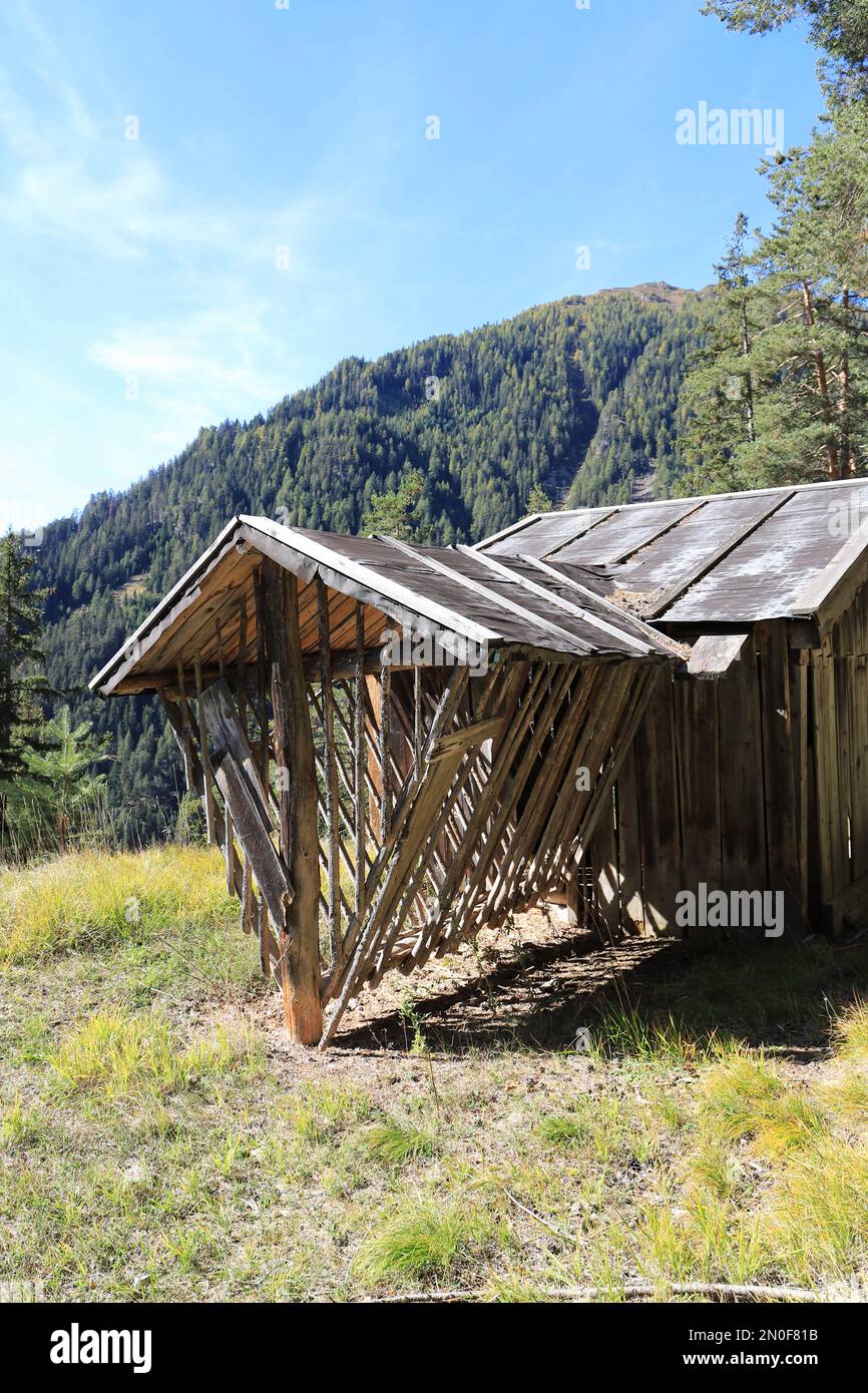a feed rack with a small hut in the alps Stock Photo - Alamy