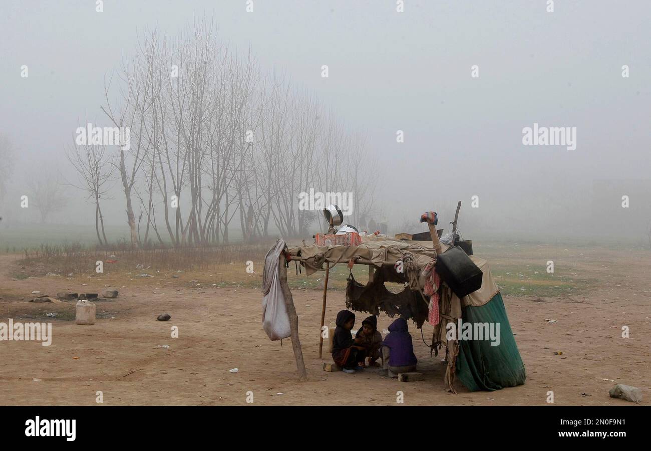 Pakistani children sit amid a thick fog that blanketed Peshawar ...