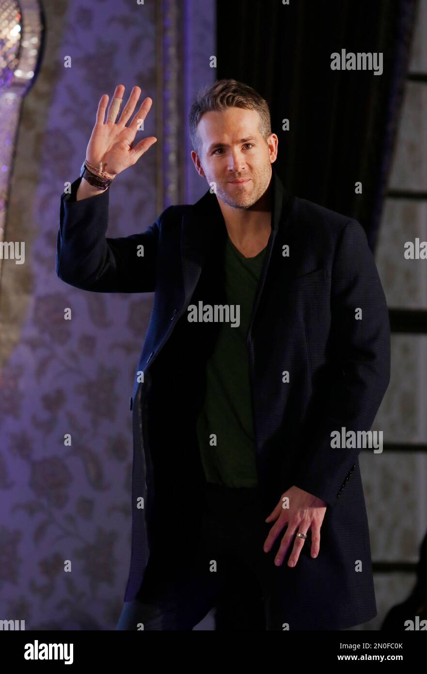 Canadian actor Ryan Reynolds waves as he arrives for a news conference ...