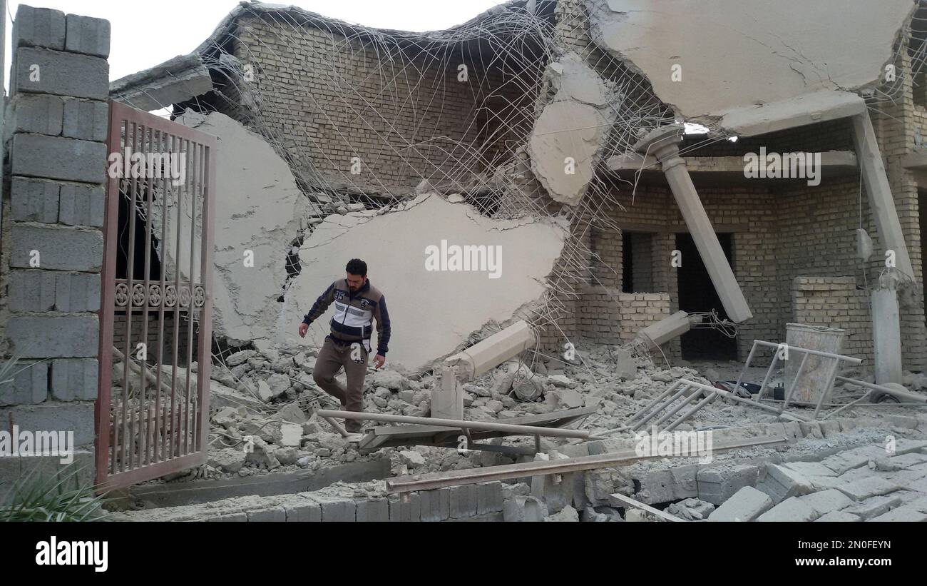 A man inspects a house damaged after a bombing in Fallujah, 40 miles ...