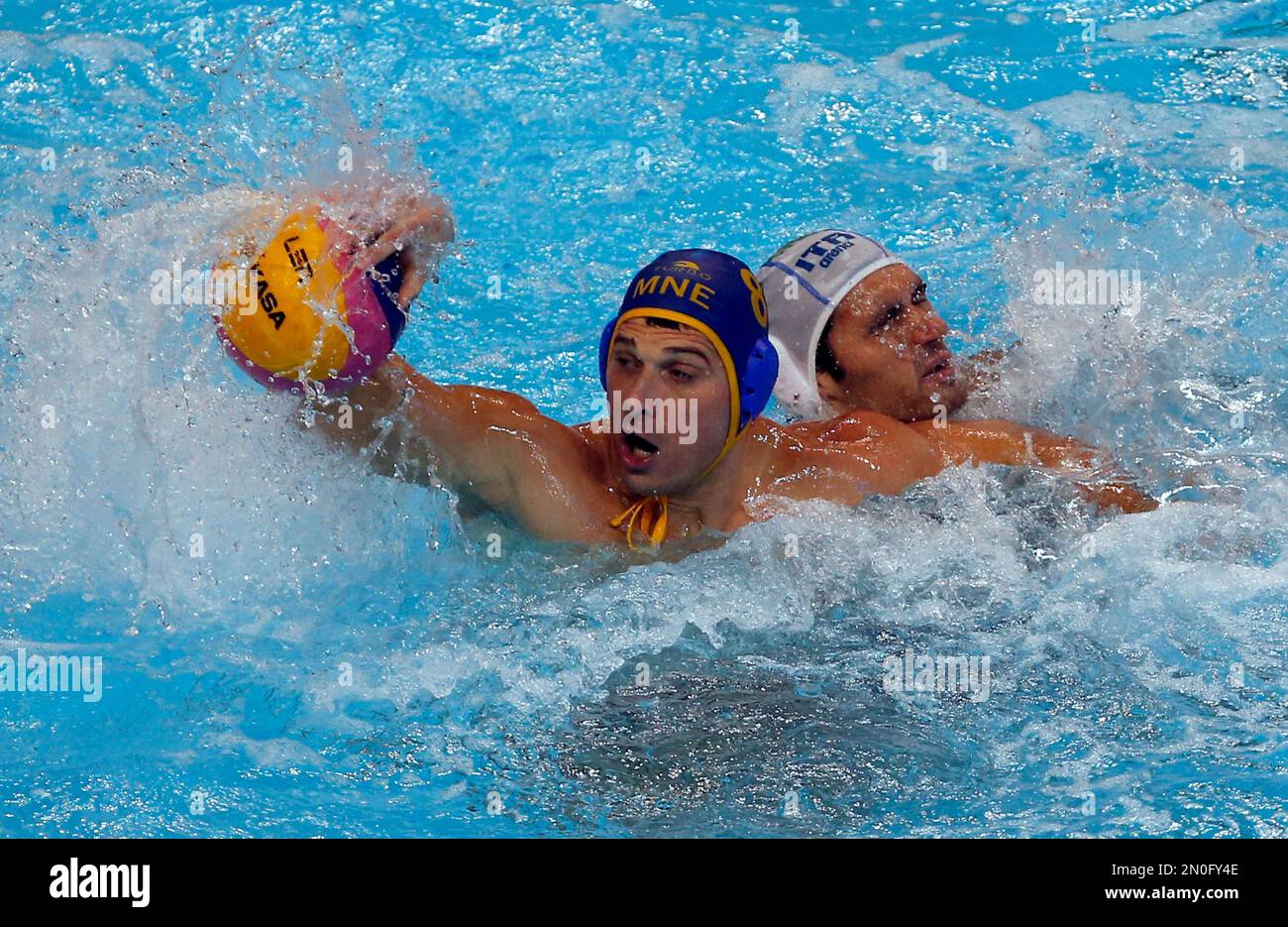 Montenegro's Nikola Janovic, left, challenges for the ball with Italy's ...