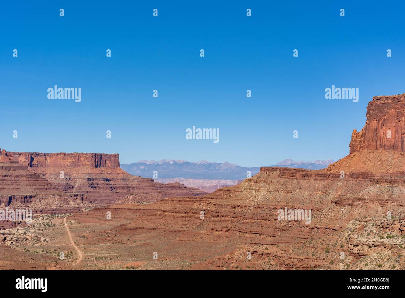 A peaceful desert landscape in a canyon with dry brown fields and rocky ...
