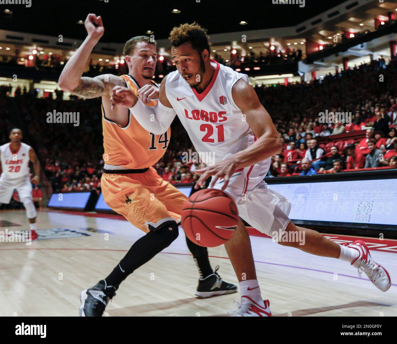 New Mexico's Xavier Adams (21) drives the baseline guarded by Wyoming's ...
