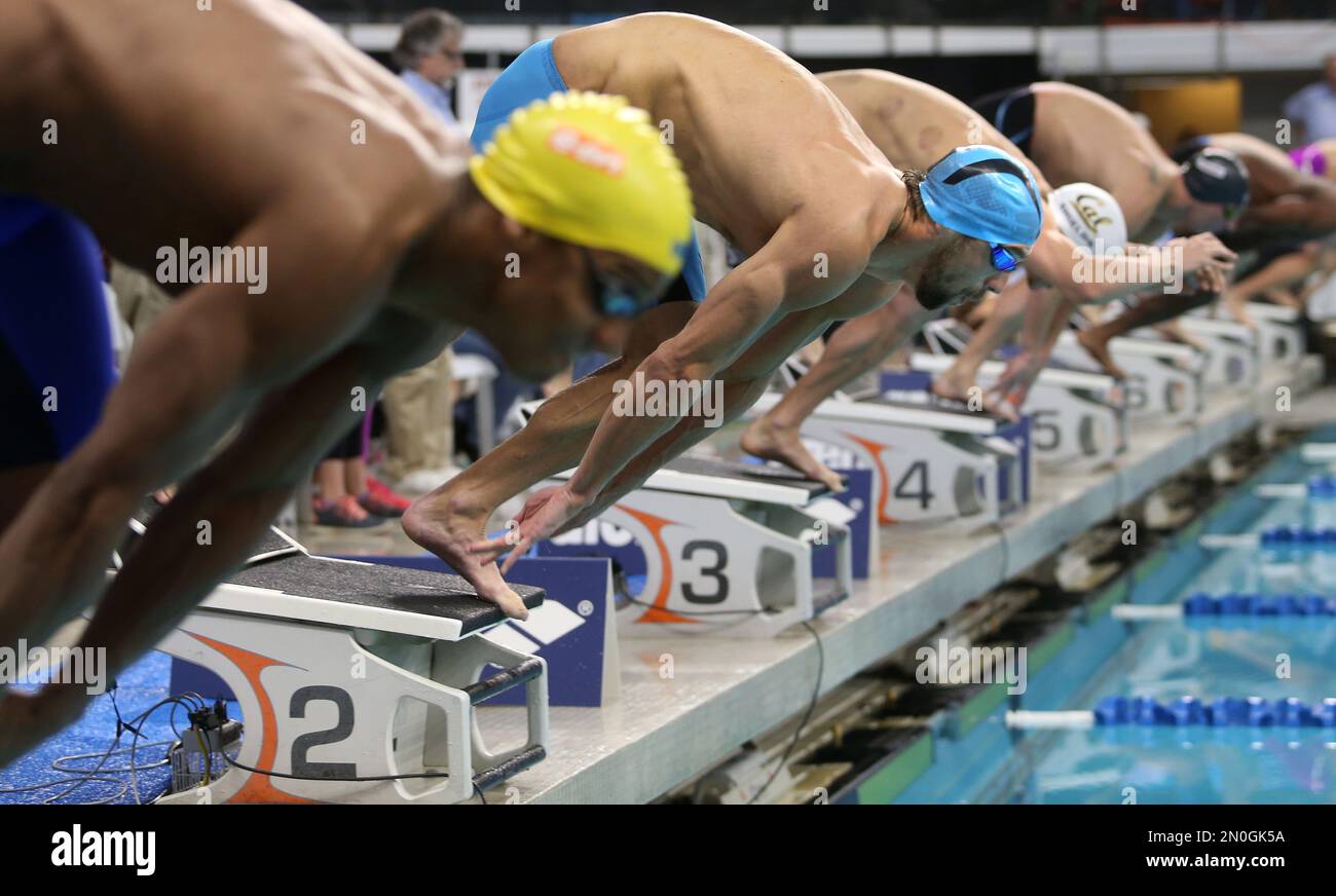 Michael Phelps, second from left, and others begin to leave the blocks ...
