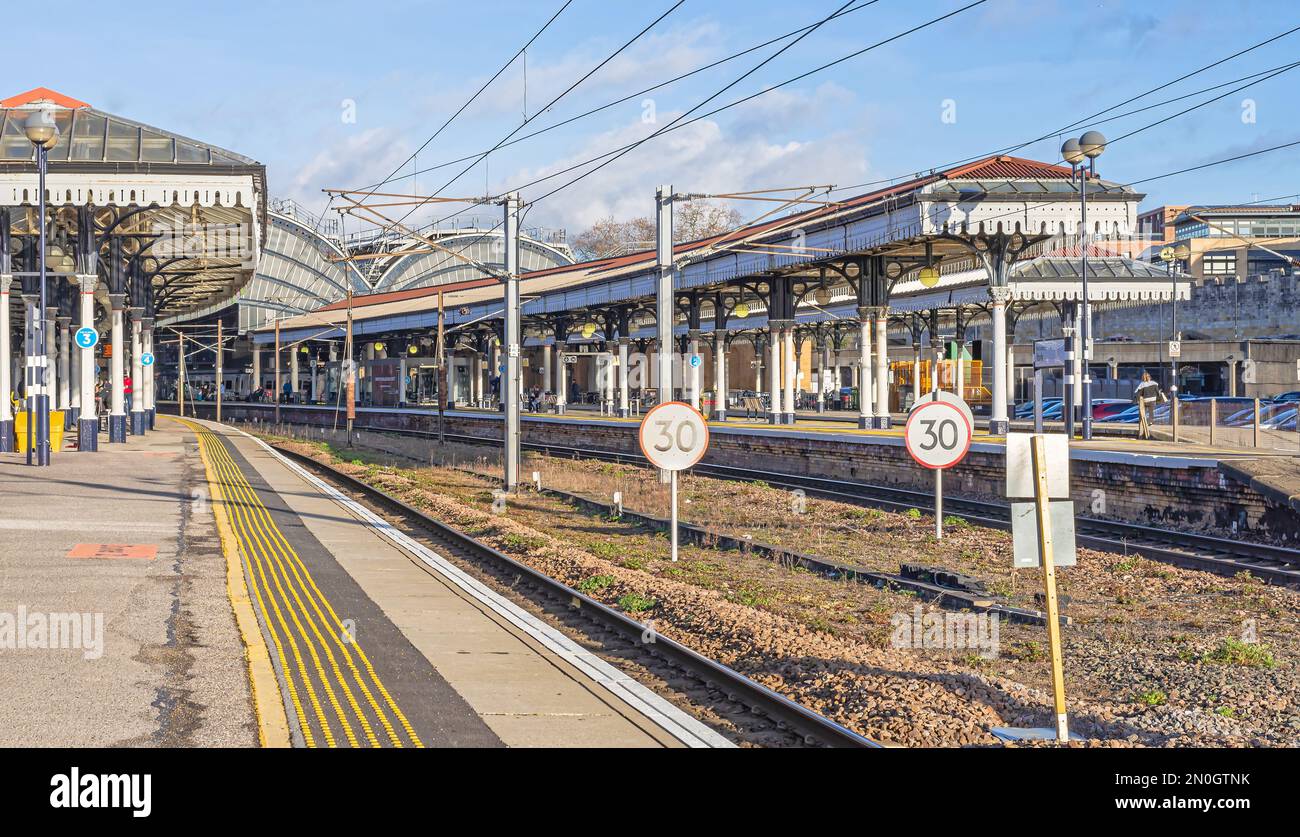 A view of a railway station with rails leading towards two iron arches ...