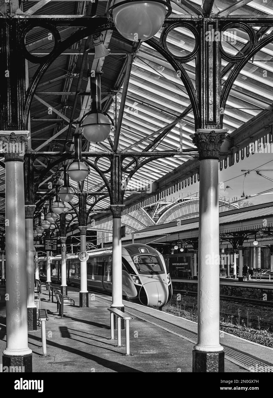A locomotive rests beside a platform covered by a historic 19th Century ...