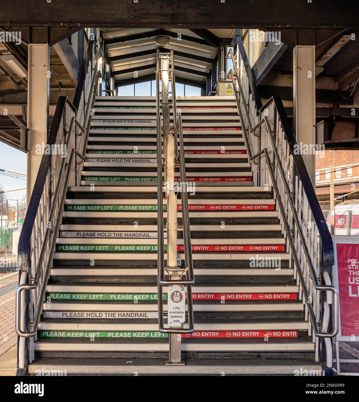 A flight of steps lead up from a railway station platform to a ...