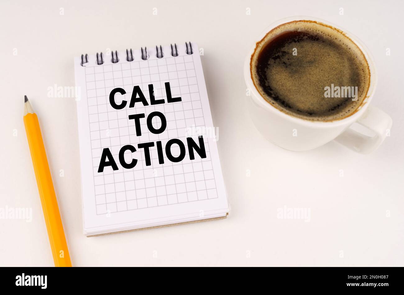 Business concept. On a white surface, a cup of coffee, a pencil and a ...