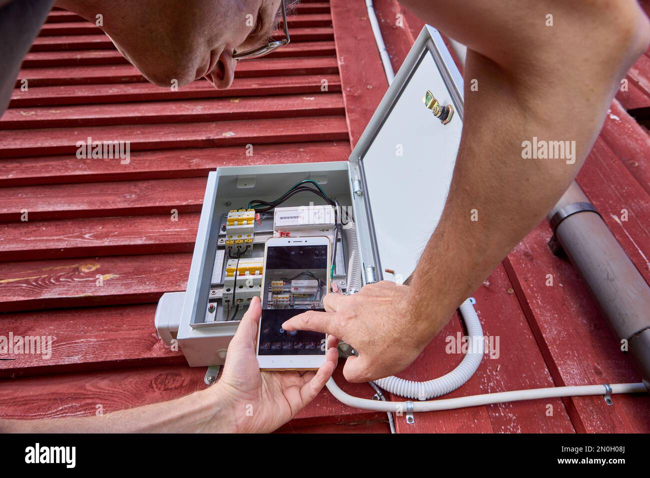 Consumer takes photo of readings of electricity meter in outdoor ...