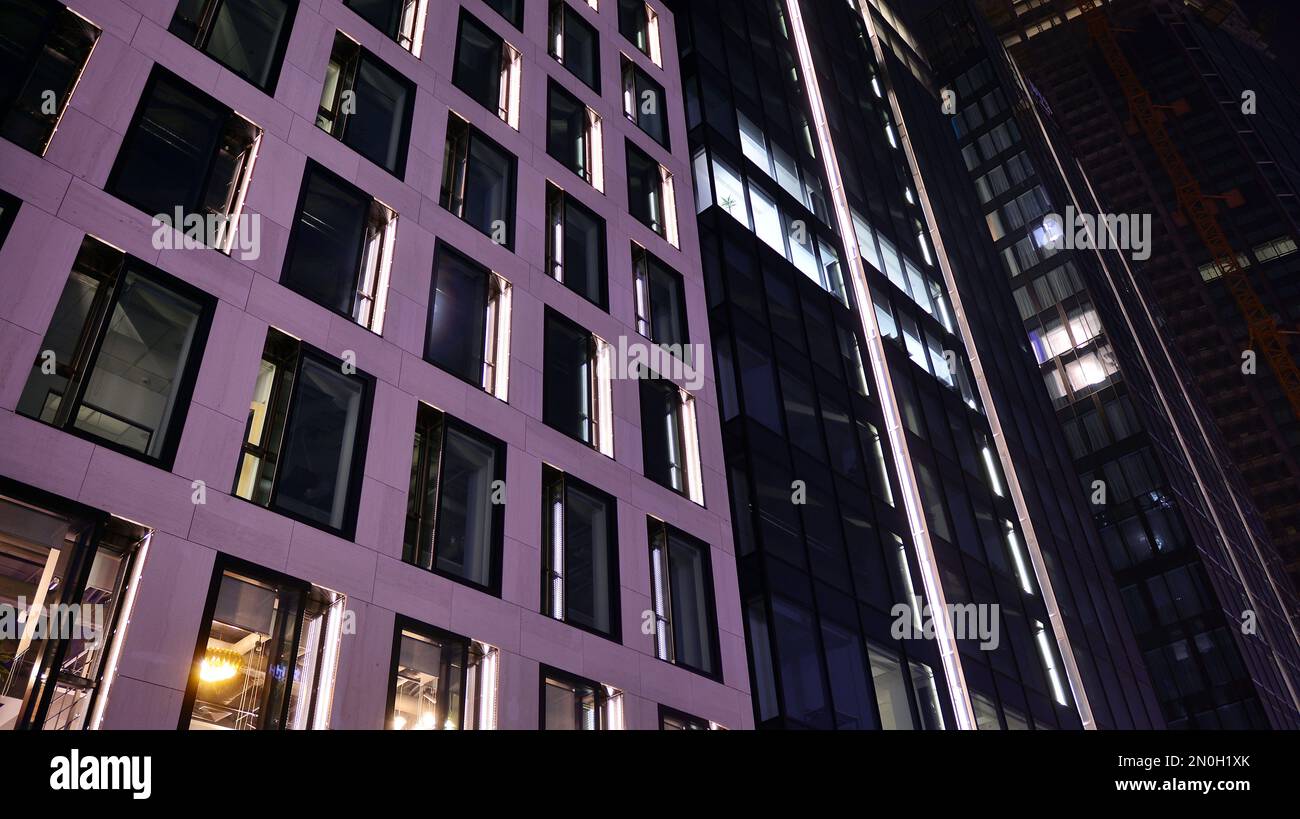 Pattern of office buildings windows illuminated at night. Lighting with ...
