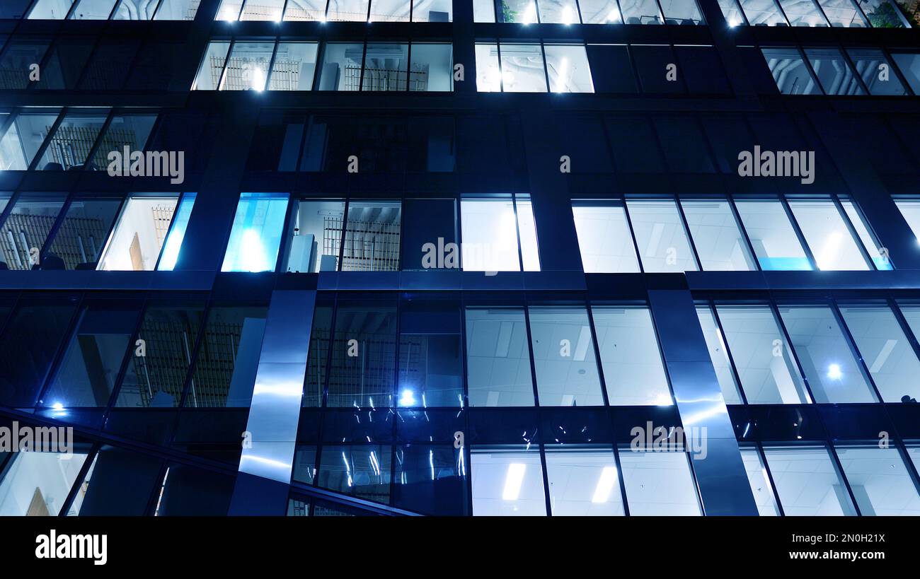 Pattern of office buildings windows illuminated at night. Lighting with ...