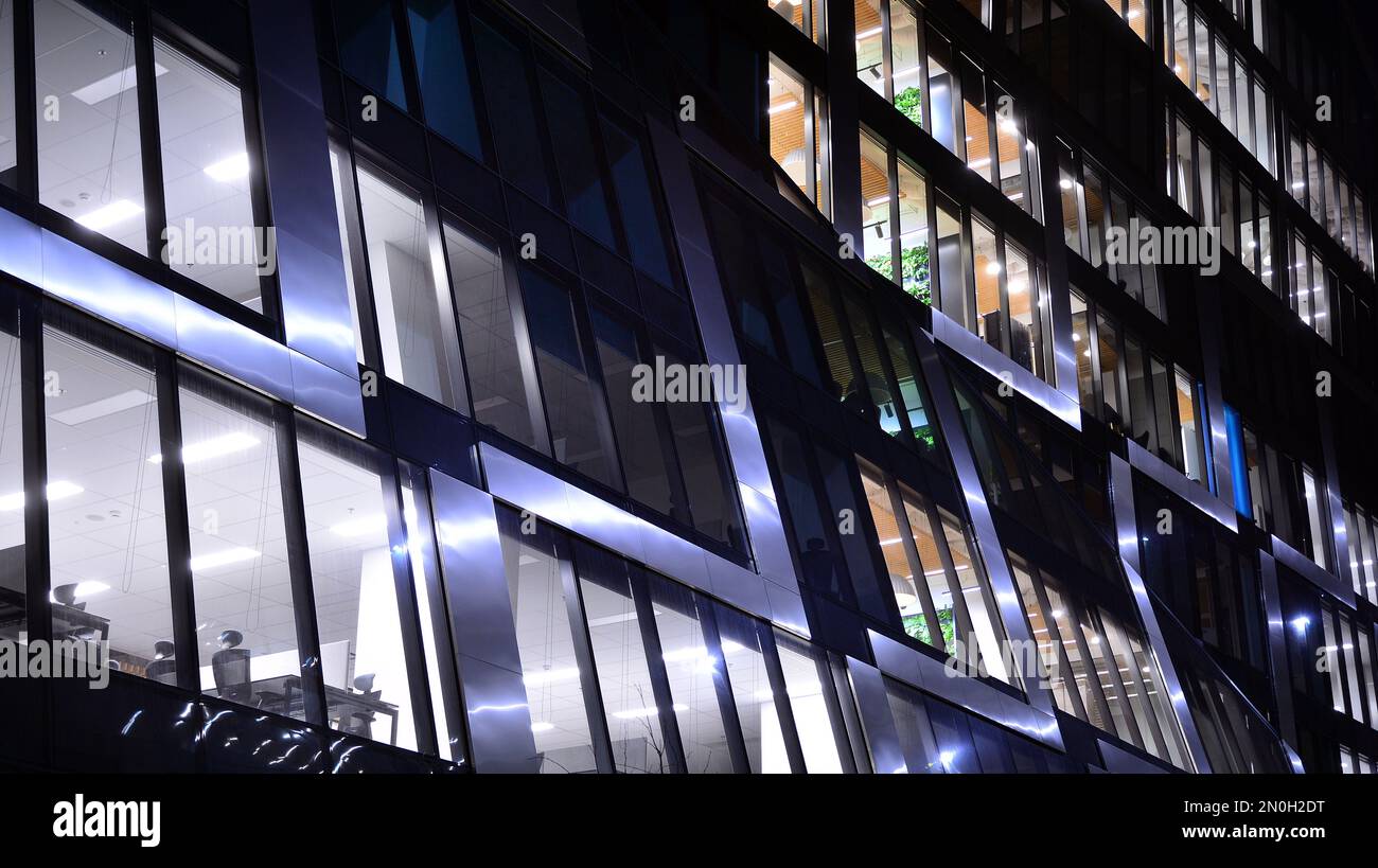 Pattern of office buildings windows illuminated at night. Lighting with ...