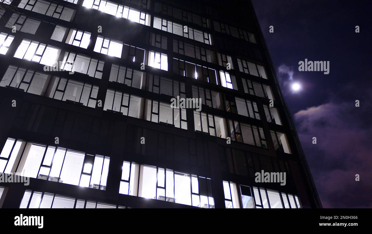 Pattern of office buildings windows illuminated at night. Lighting with ...
