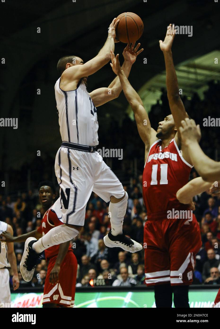 Northwestern Wildcats guard Tre Demps (14) passes over Wisconsin guard ...