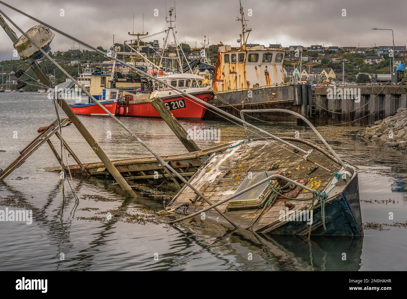 Old, half sunk, a fishing boat in front of other workboats, and ships ...