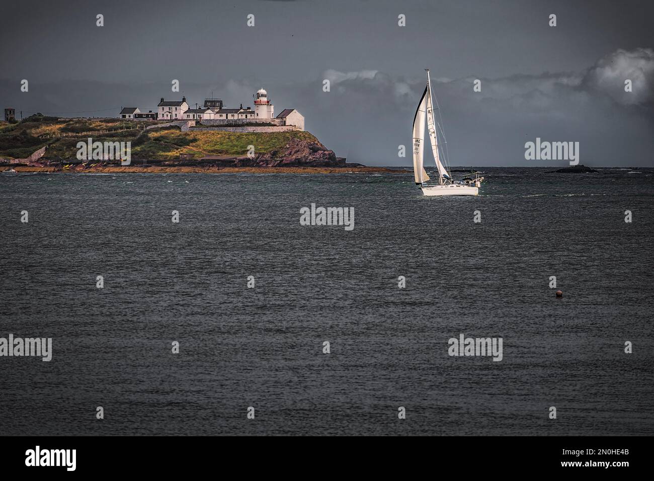 Sailing boat in front of Roche’s Point Lighthouse. Co. Cork, Ireland ...