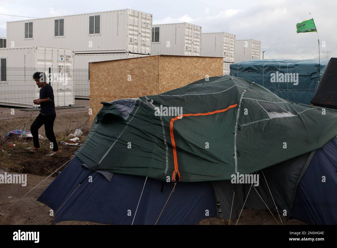 A man walks past containers, at rear, at the entrance of the Calais ...