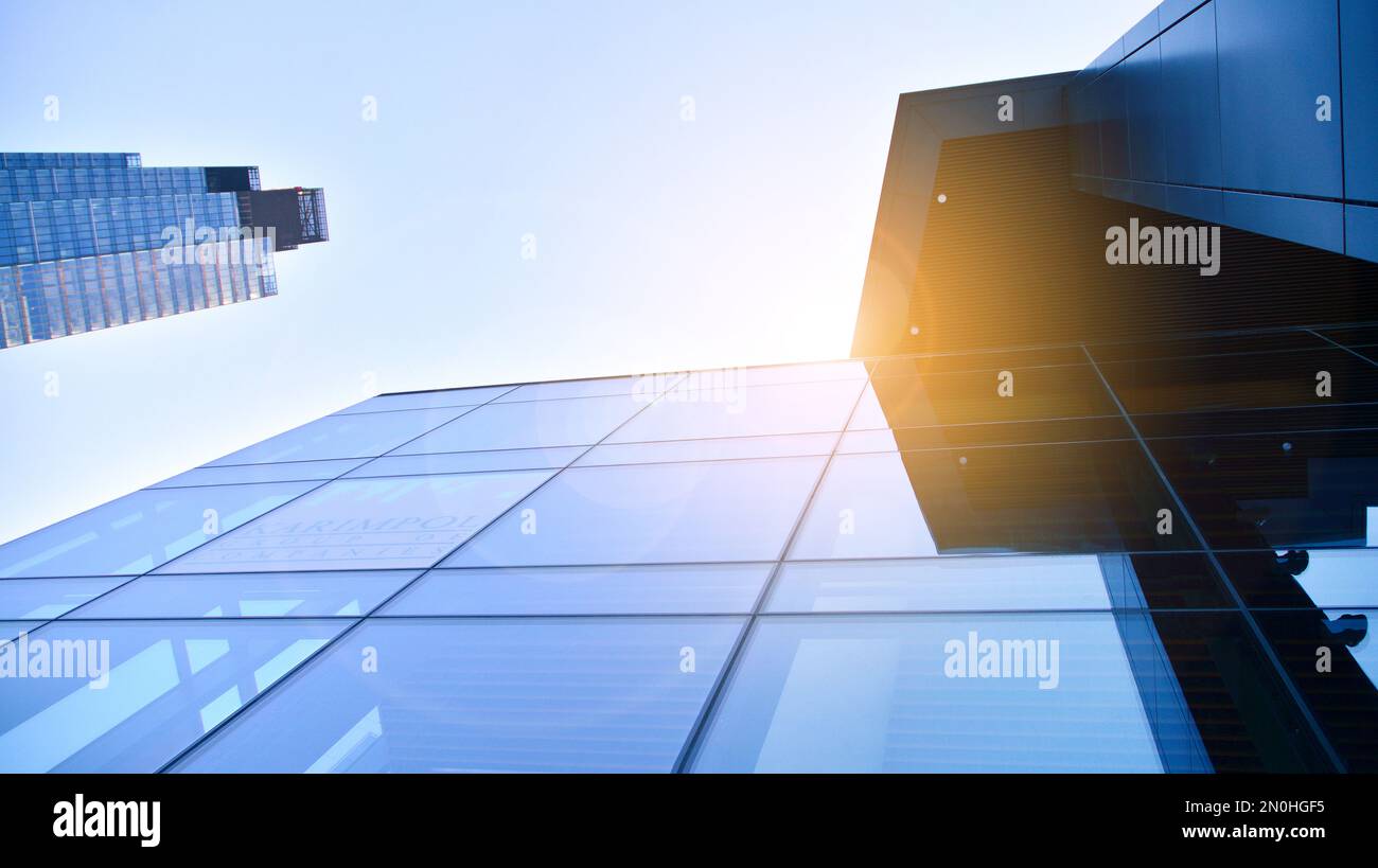 Glass facade of the buildings with a blue sky. Skyscrapers in the ...