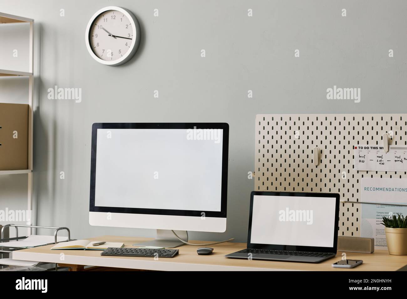 Minimal office workplace setup with two screen mockups on desk, copy ...